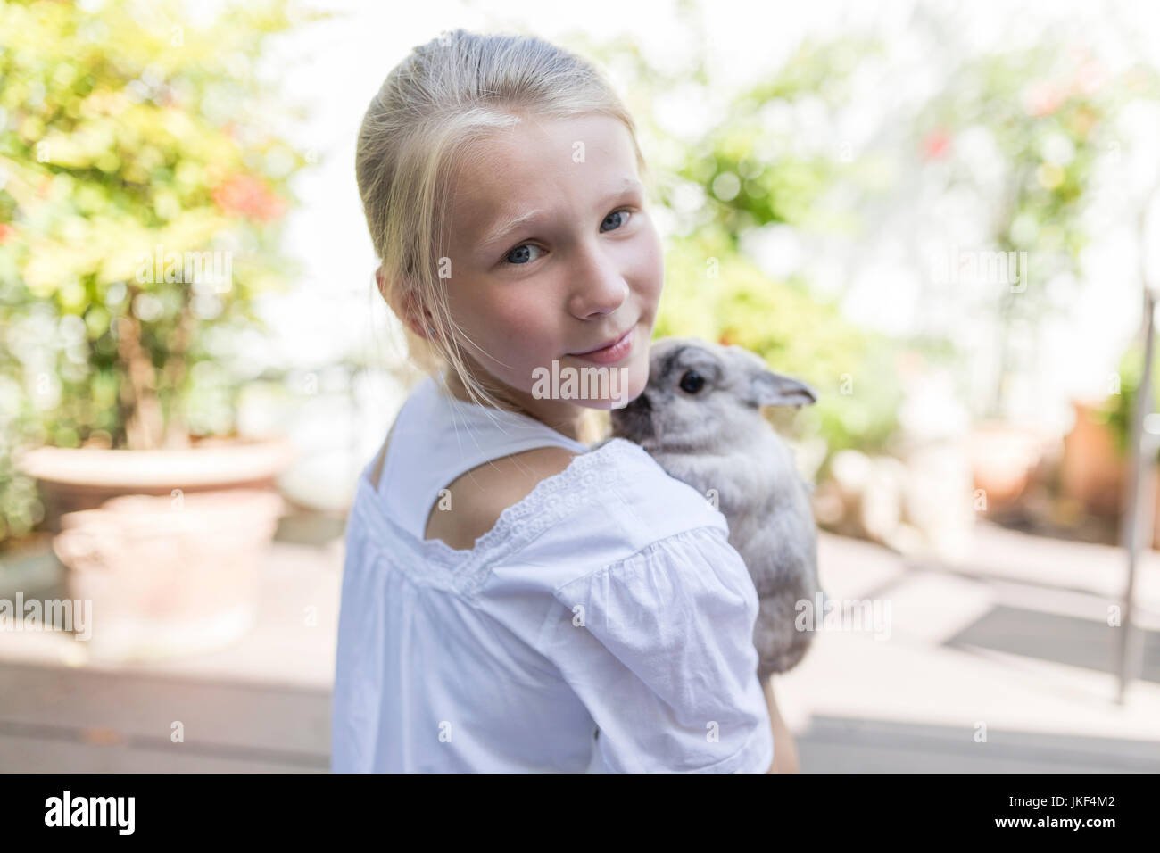 Portrait of girl with rabbit outdoors Stock Photo - Alamy