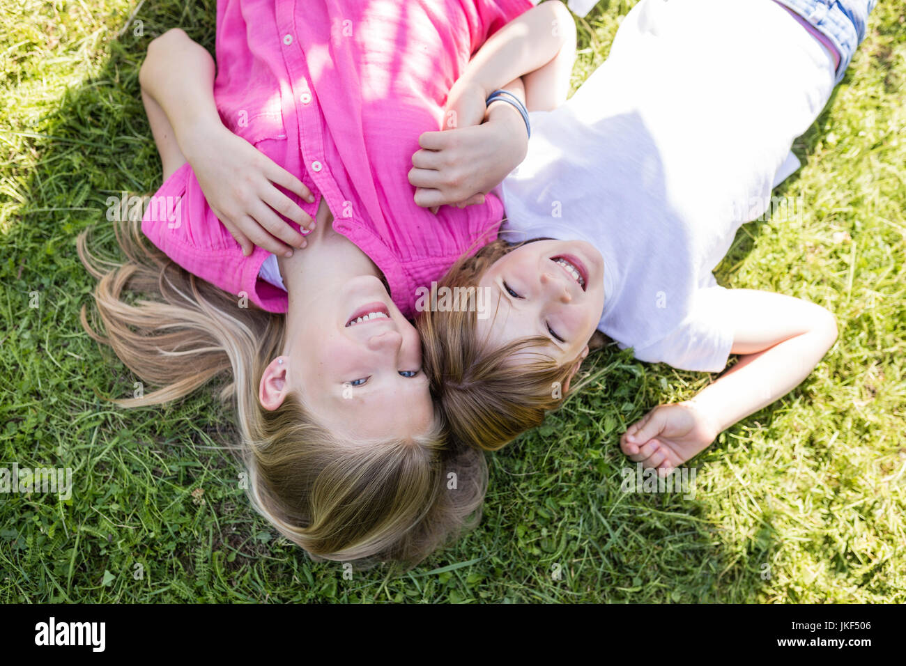 Two happy sisters lying in meadow Stock Photo - Alamy