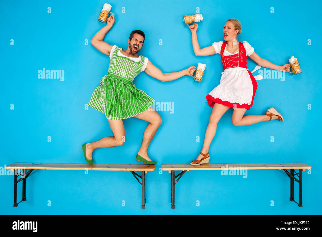 Man and woman at the Oktoberfest dancing on beer benches Stock Photo ...