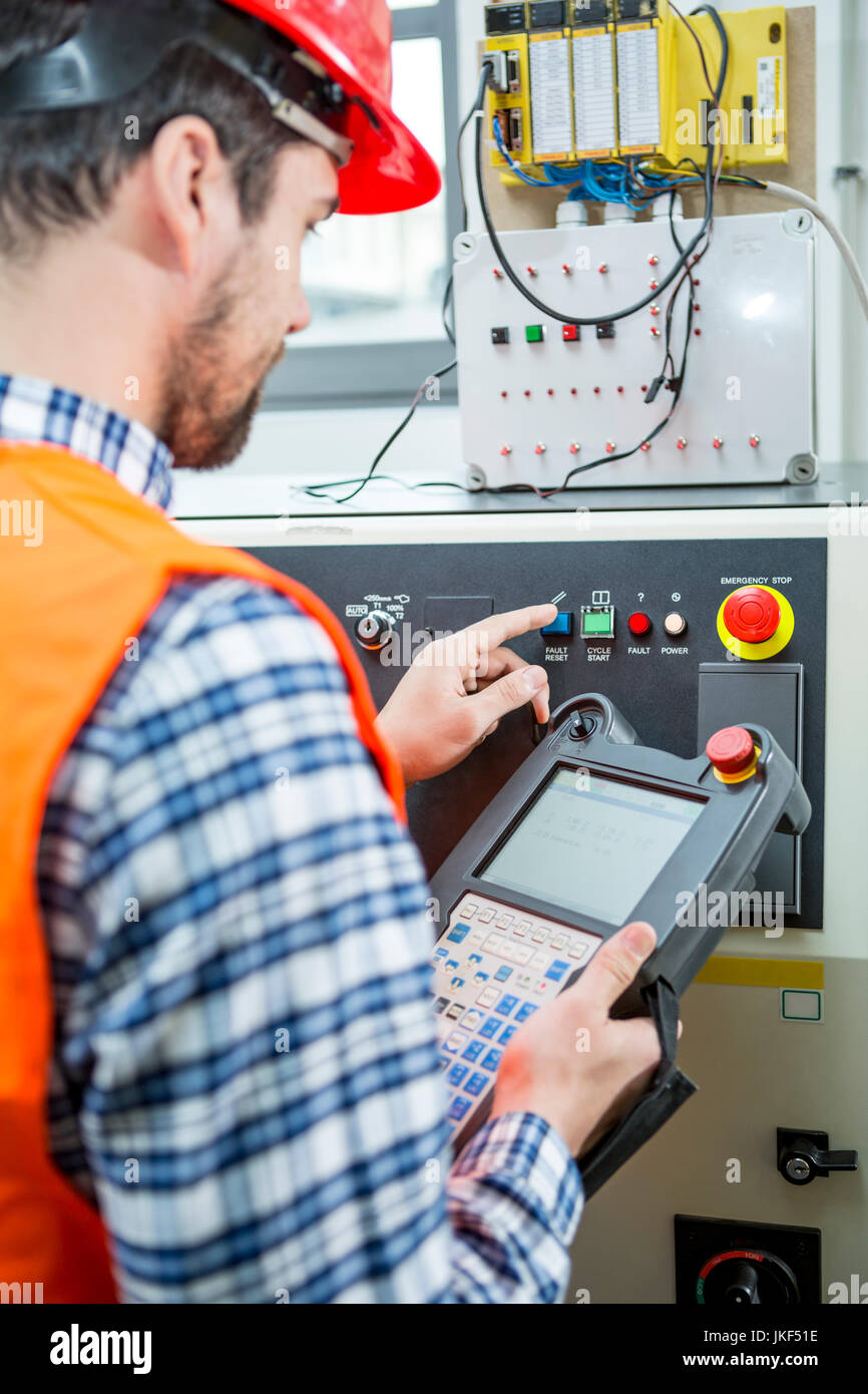 Close-up of man using control for industrial robot Stock Photo - Alamy