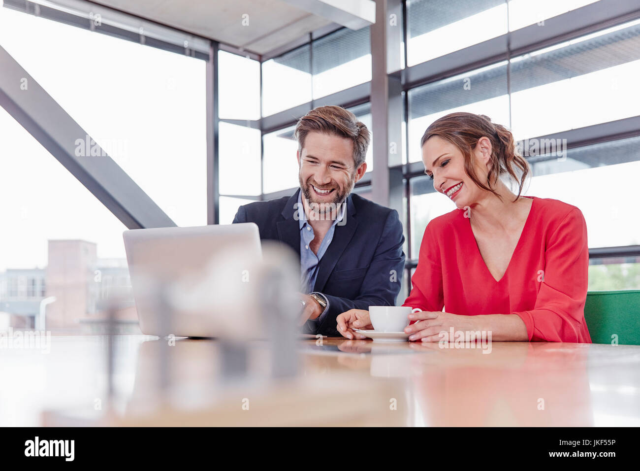Happy colleagues in office sharing laptop Stock Photo - Alamy