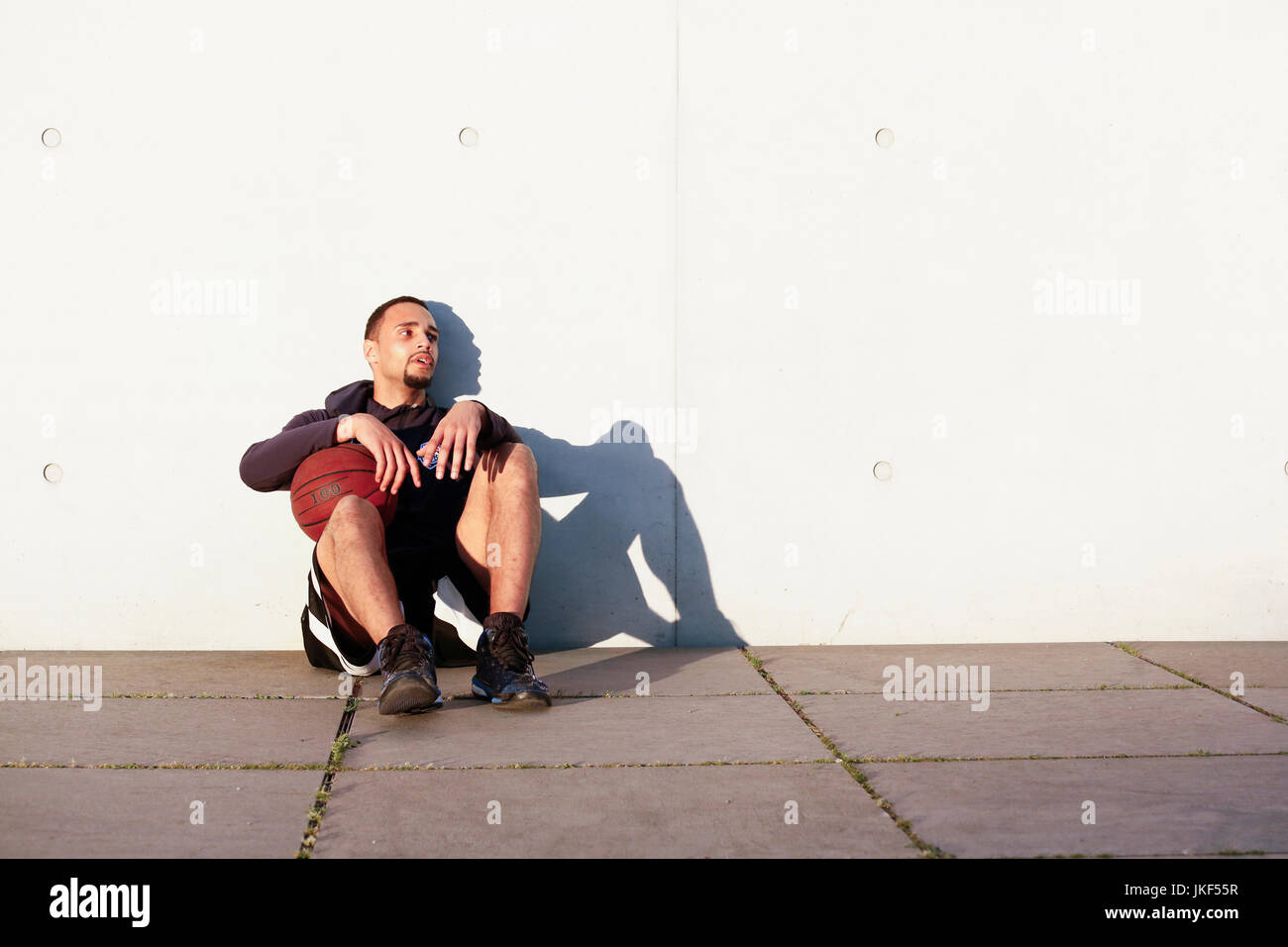 Young man with basketball having a break Stock Photo - Alamy