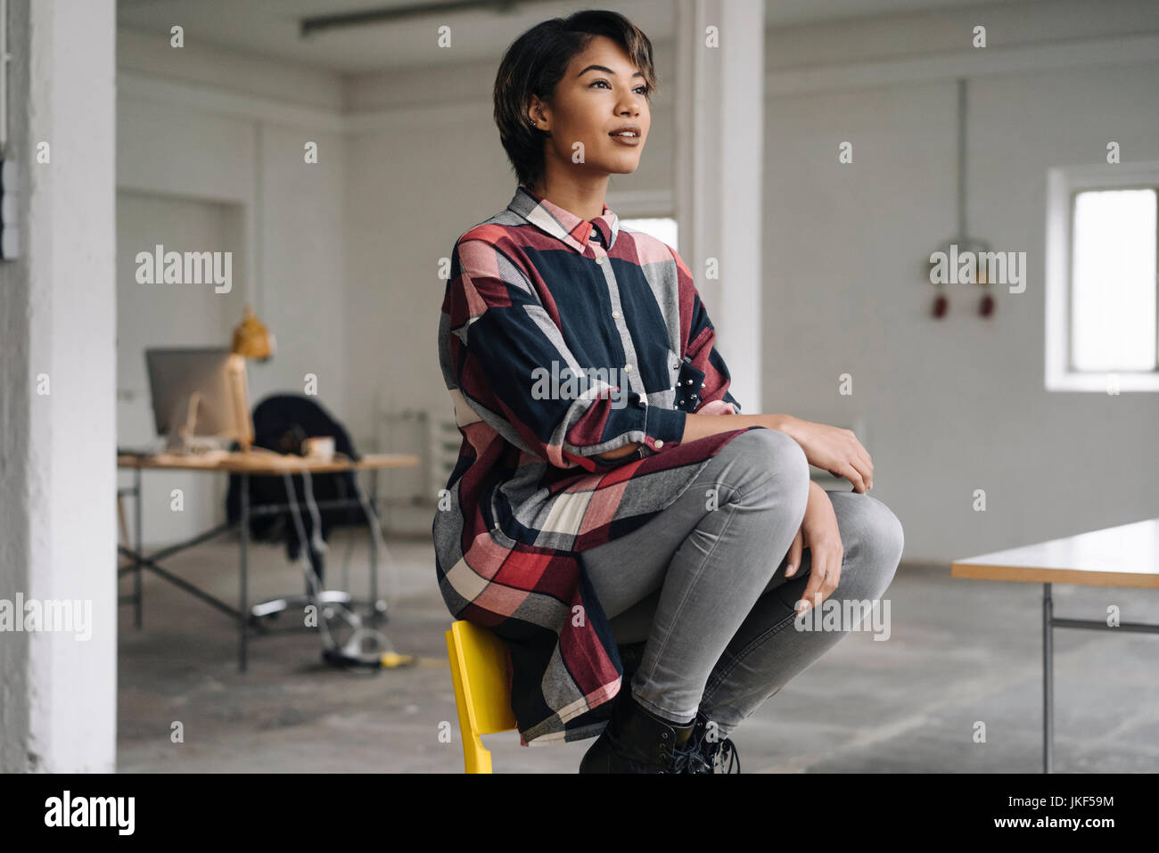 Woman sitting on chair thinking Stock Photo - Alamy