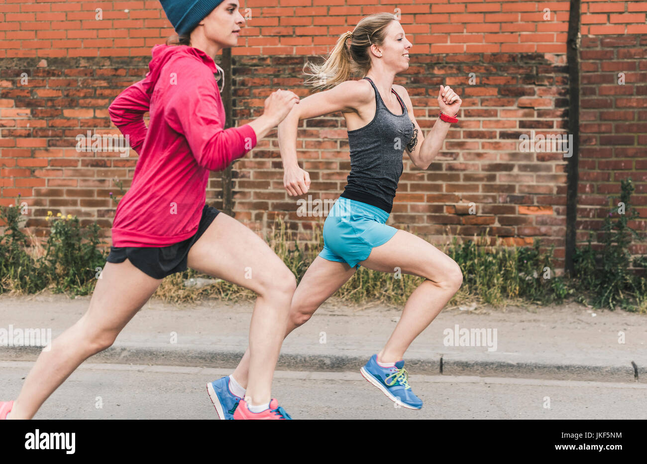 Two women running on the street Stock Photo - Alamy