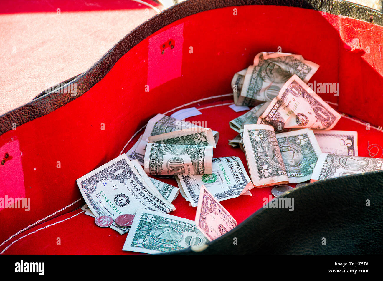 American dollar bills and coin tip money in red line guitar case Stock ...