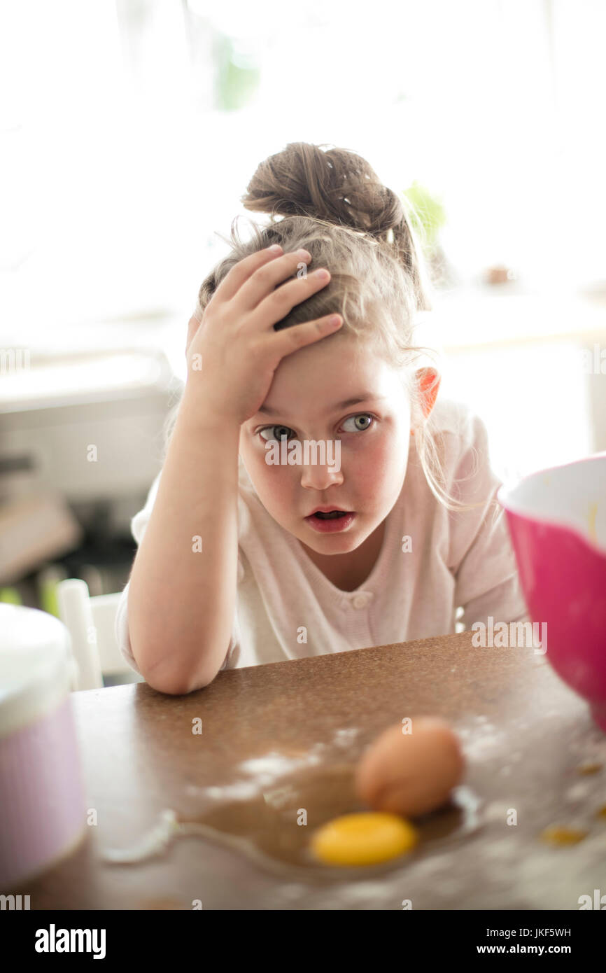 Portrait of embarrassed little girl in the kitchen Stock Photo - Alamy