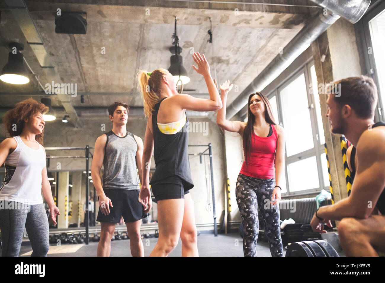 Group of young people high fiving in gym Stock Photo - Alamy