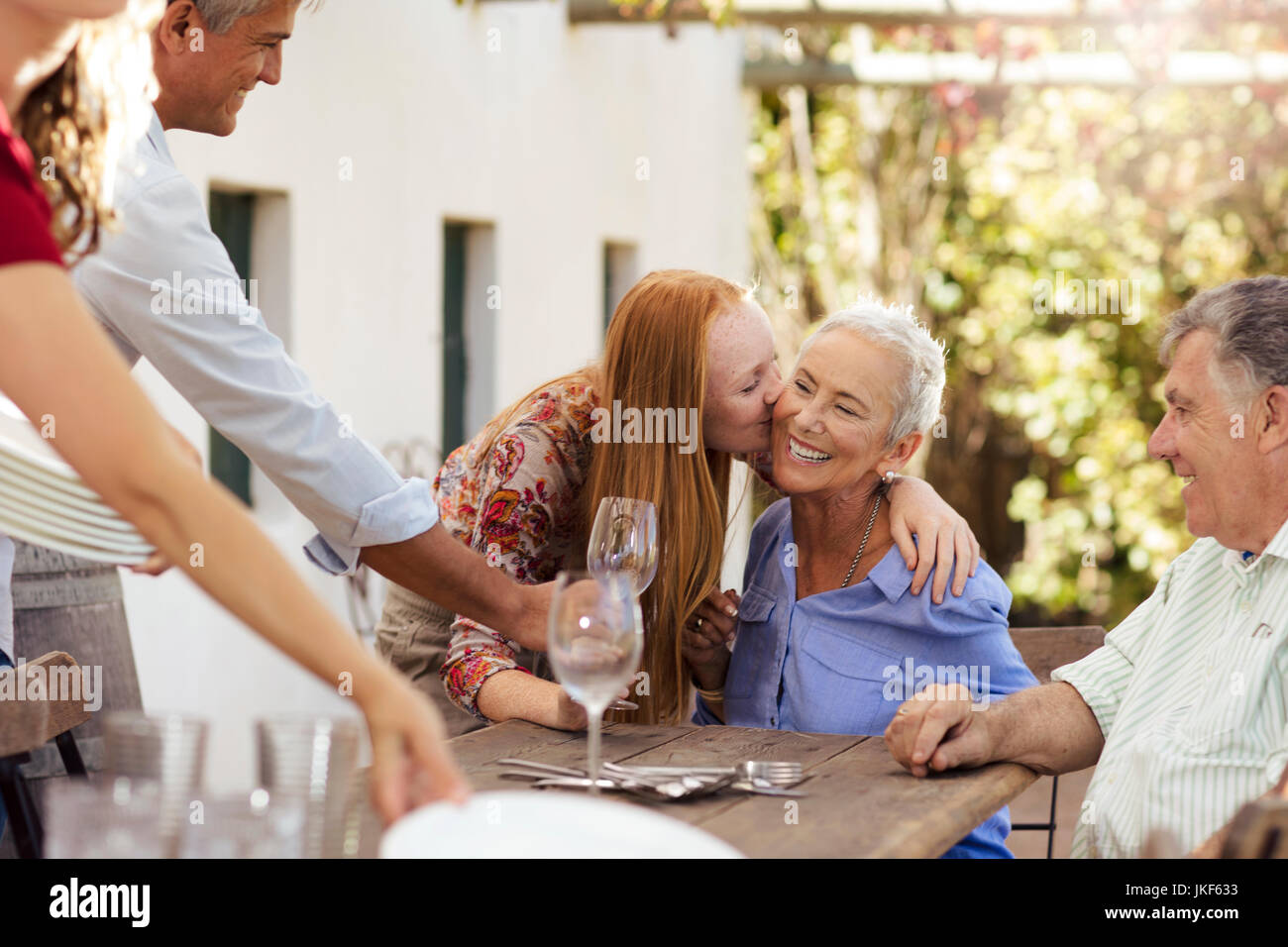Happy family setting table outside for lunch Stock Photo - Alamy