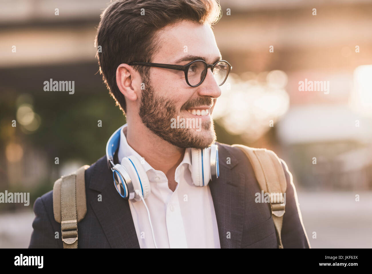 Smiling young man outdoors looking sideways Stock Photo - Alamy