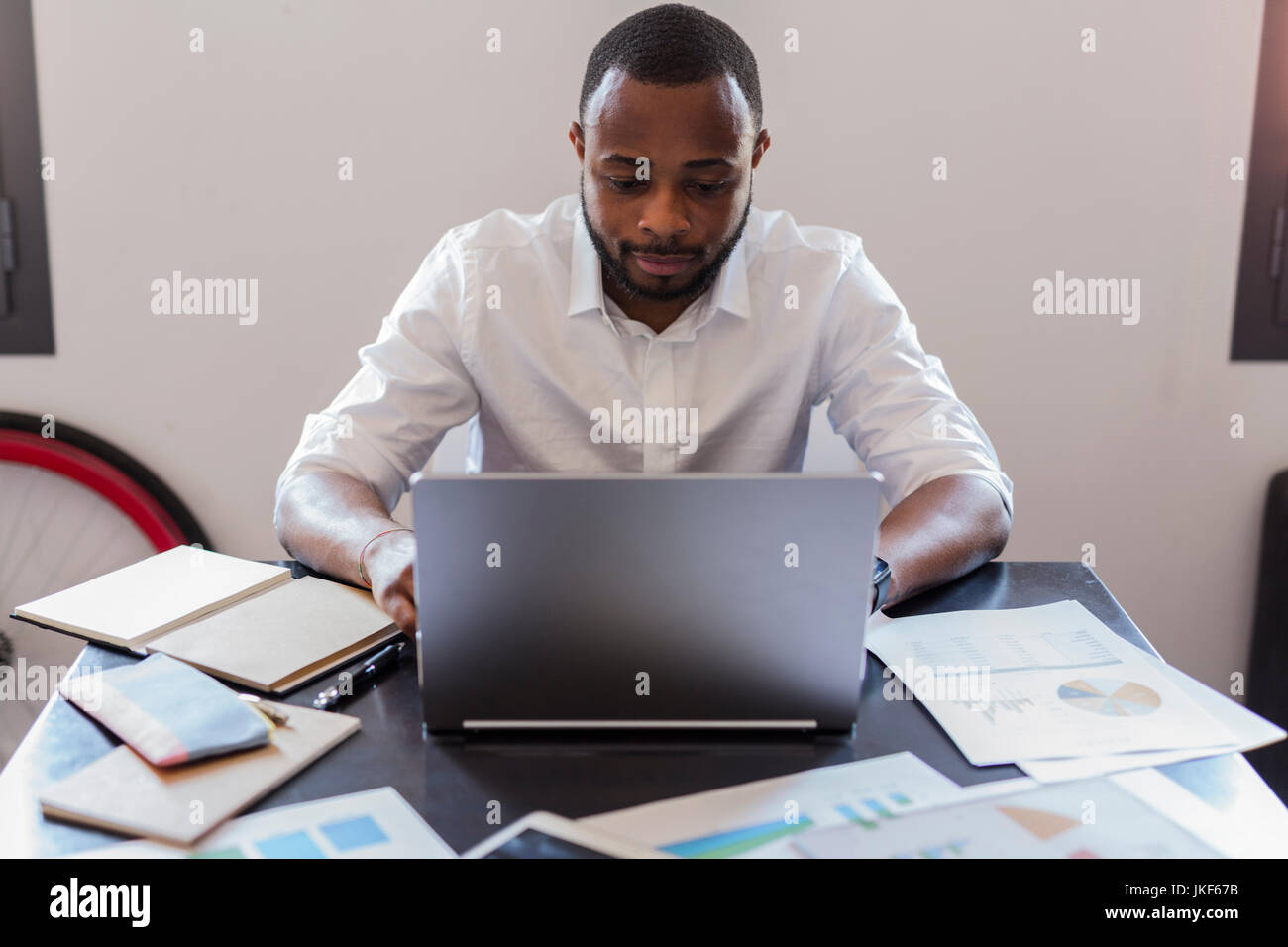 Man using laptop at desk in home office Stock Photo - Alamy