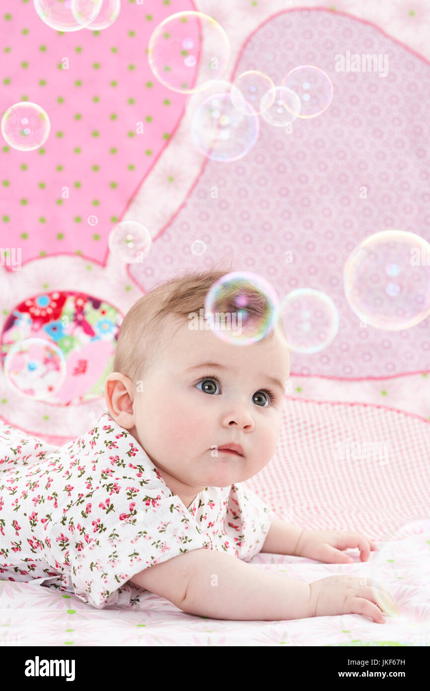 Portrait of baby girl watching soap bubbles Stock Photo - Alamy