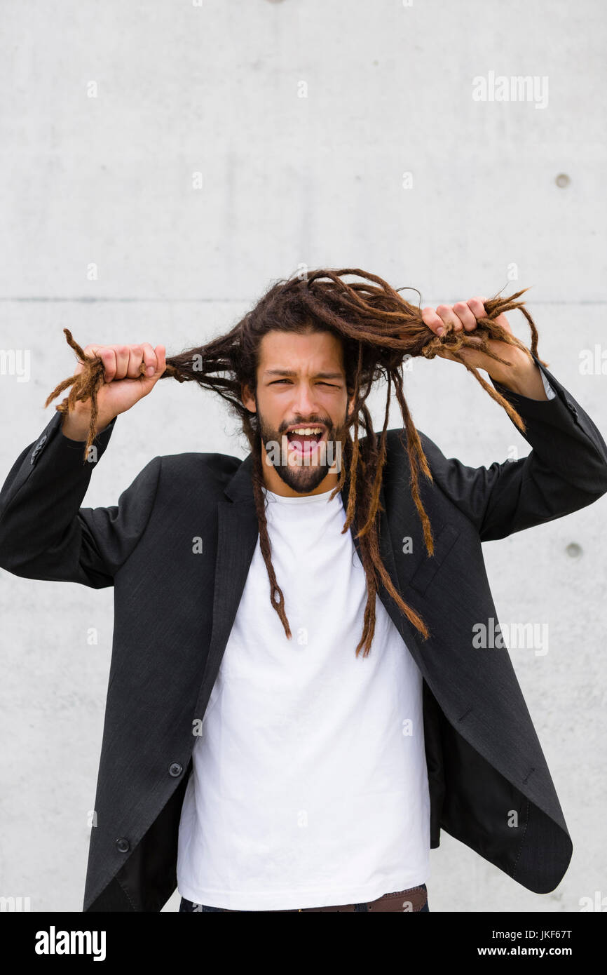 Portrait of young businessman with dreadlocks pulling funny faces Stock ...