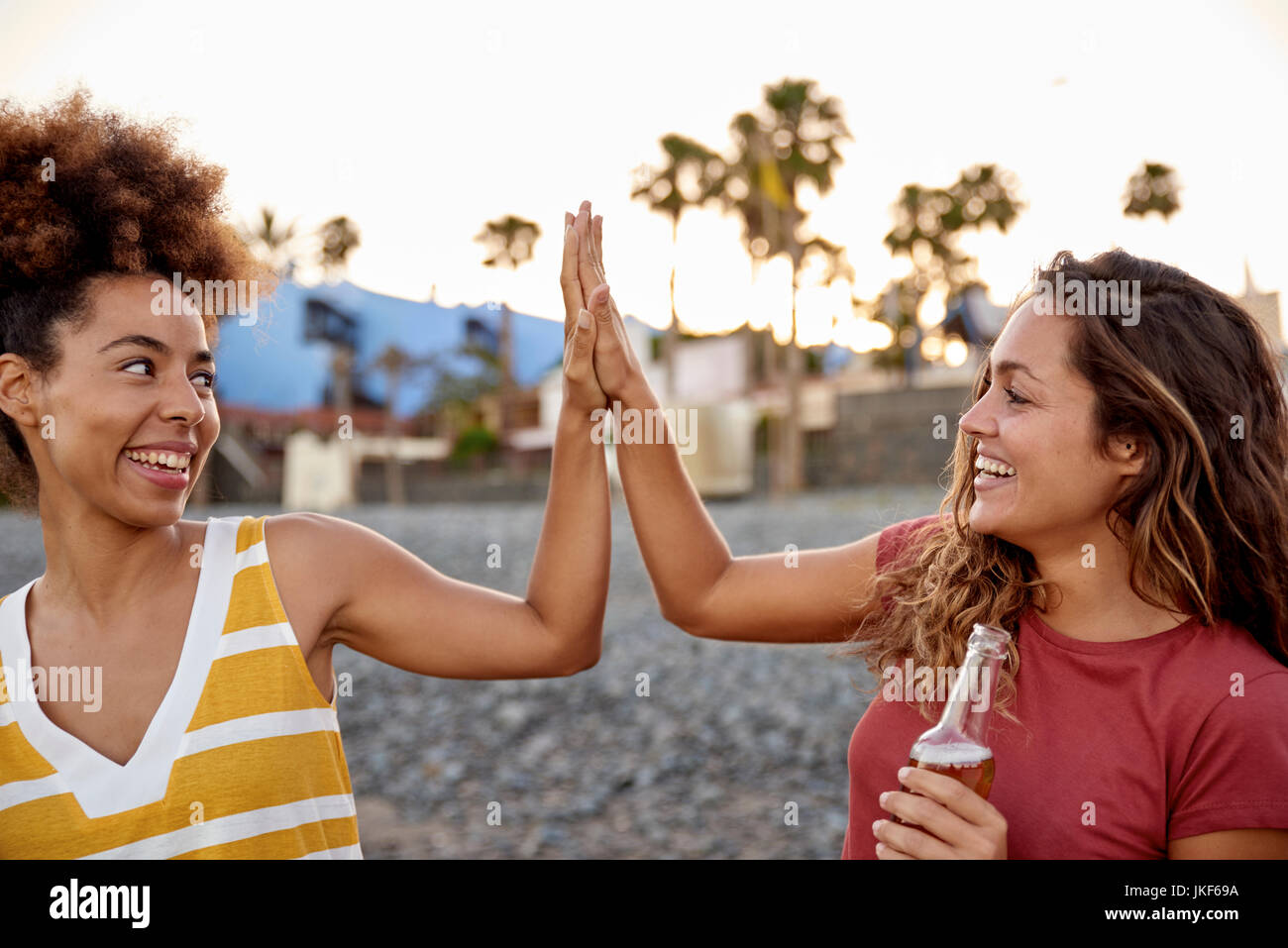 Two best friends high fiving on the beach Stock Photo - Alamy