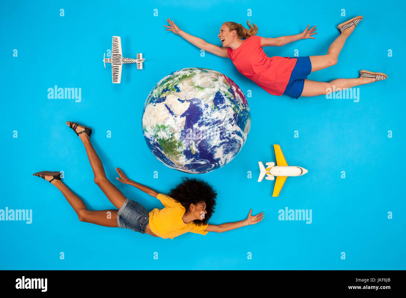 Two women and airplanes flying around the globe Stock Photo - Alamy