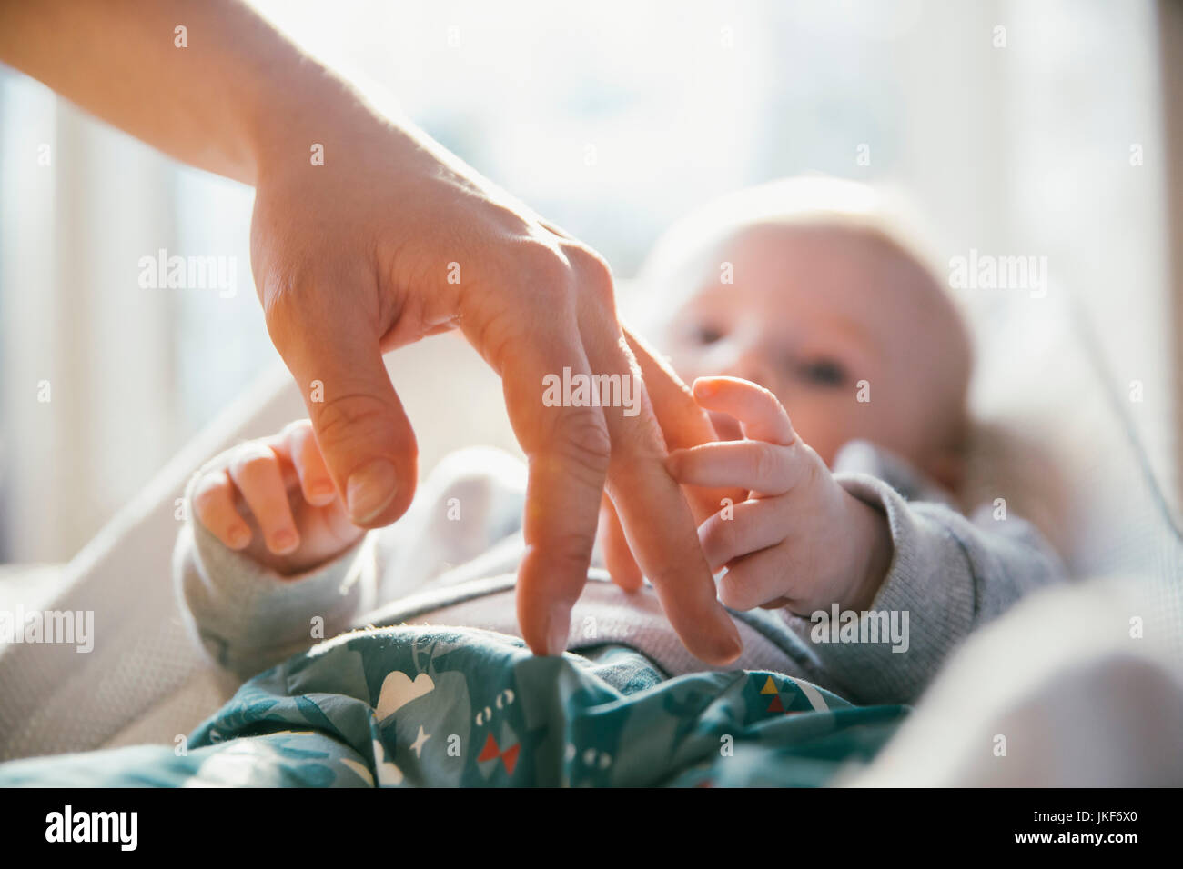 Baby touching woman's hand Stock Photo - Alamy