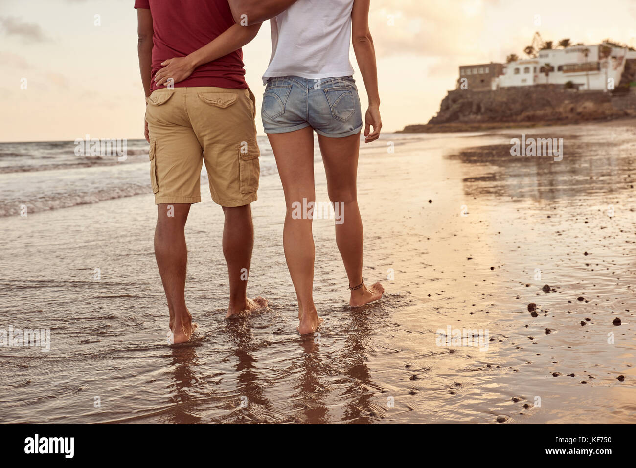 Back view of couple in love walking at seaside Stock Photo - Alamy