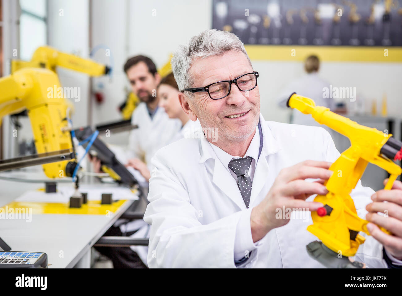 Engineer holding model of an industrial robot Stock Photo - Alamy