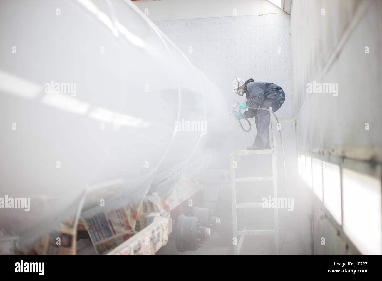 Industrial worker spray painting and wearing protective clothing Stock ...