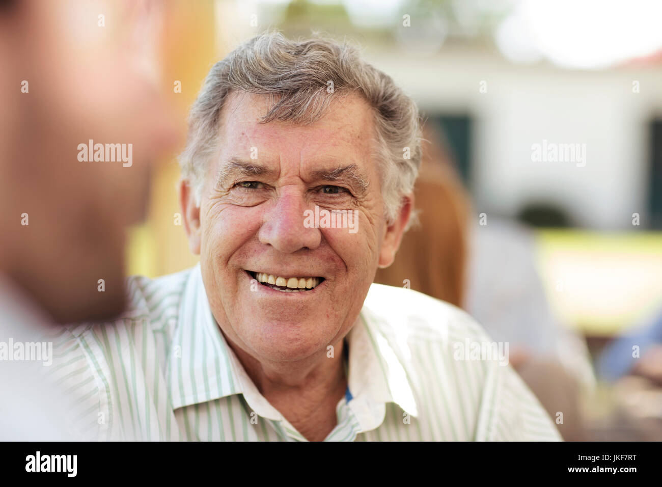 Smiling senior man socializing on a garden party Stock Photo - Alamy