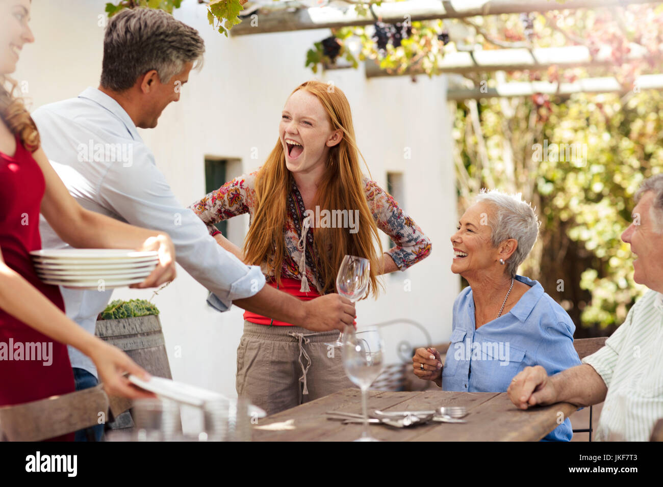 Happy family setting table outside for lunch Stock Photo - Alamy