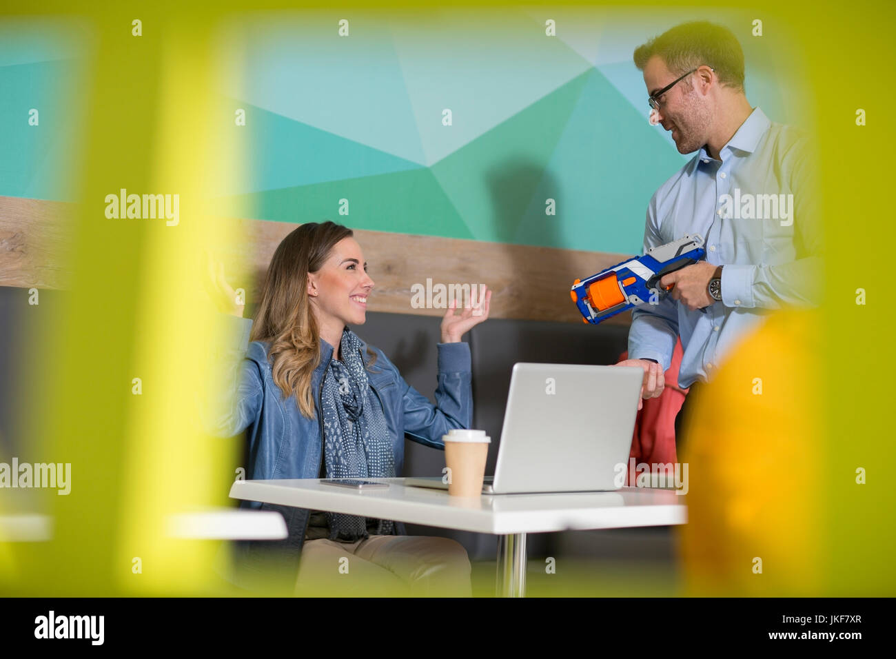 Colleagues having fun in office break area with toy gun Stock Photo - Alamy