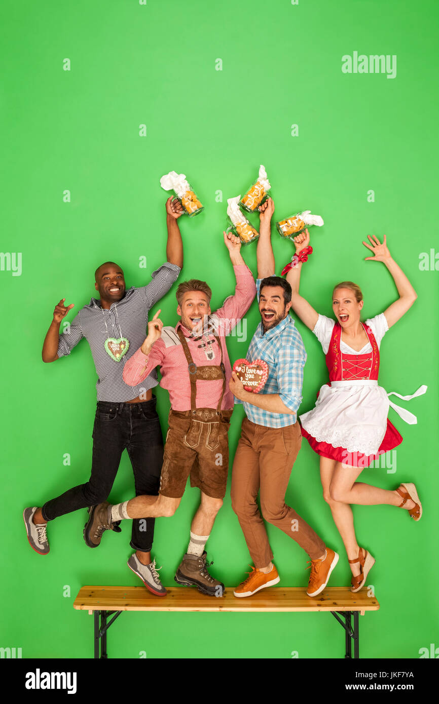 Group of people at the Oktoberfest dancing on beer benchesm drinking ...