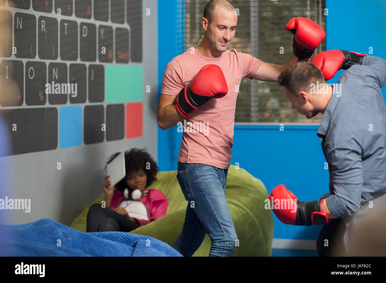 Colleagues boxing in office lounge Stock Photo - Alamy