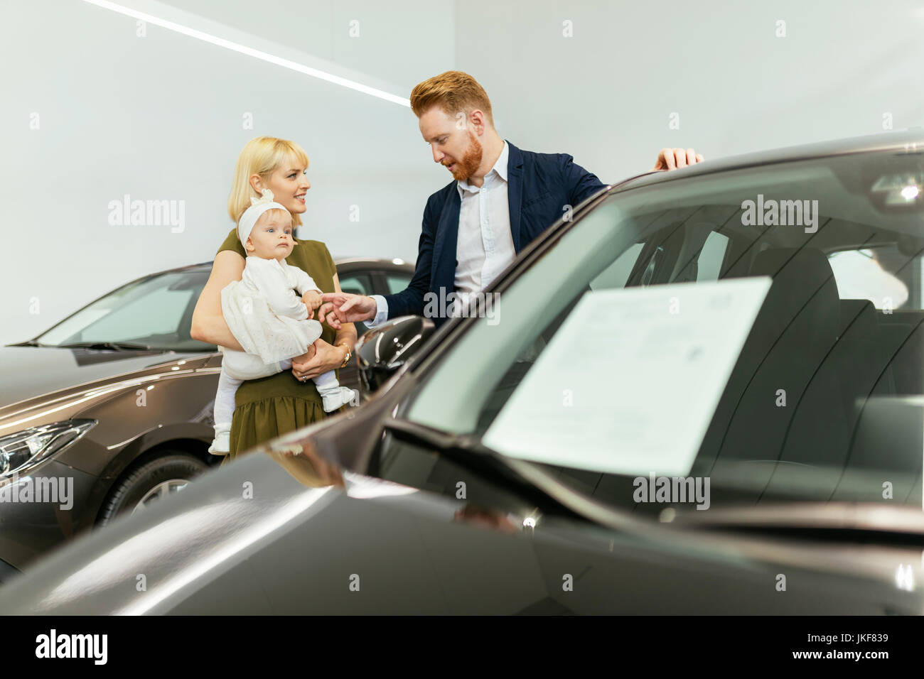 Family in car dealership choosing family vehicle Stock Photo - Alamy