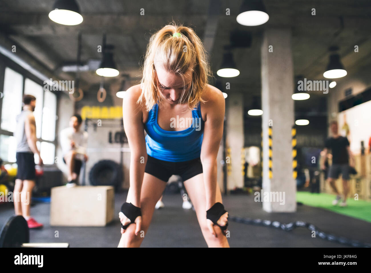 Exhausted young woman in gym having a break Stock Photo - Alamy