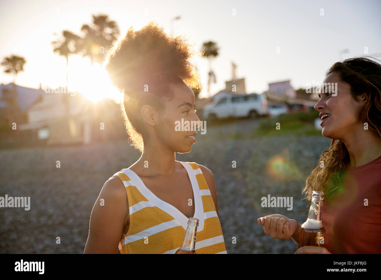 Two friends talking on the beach at sunset Stock Photo - Alamy