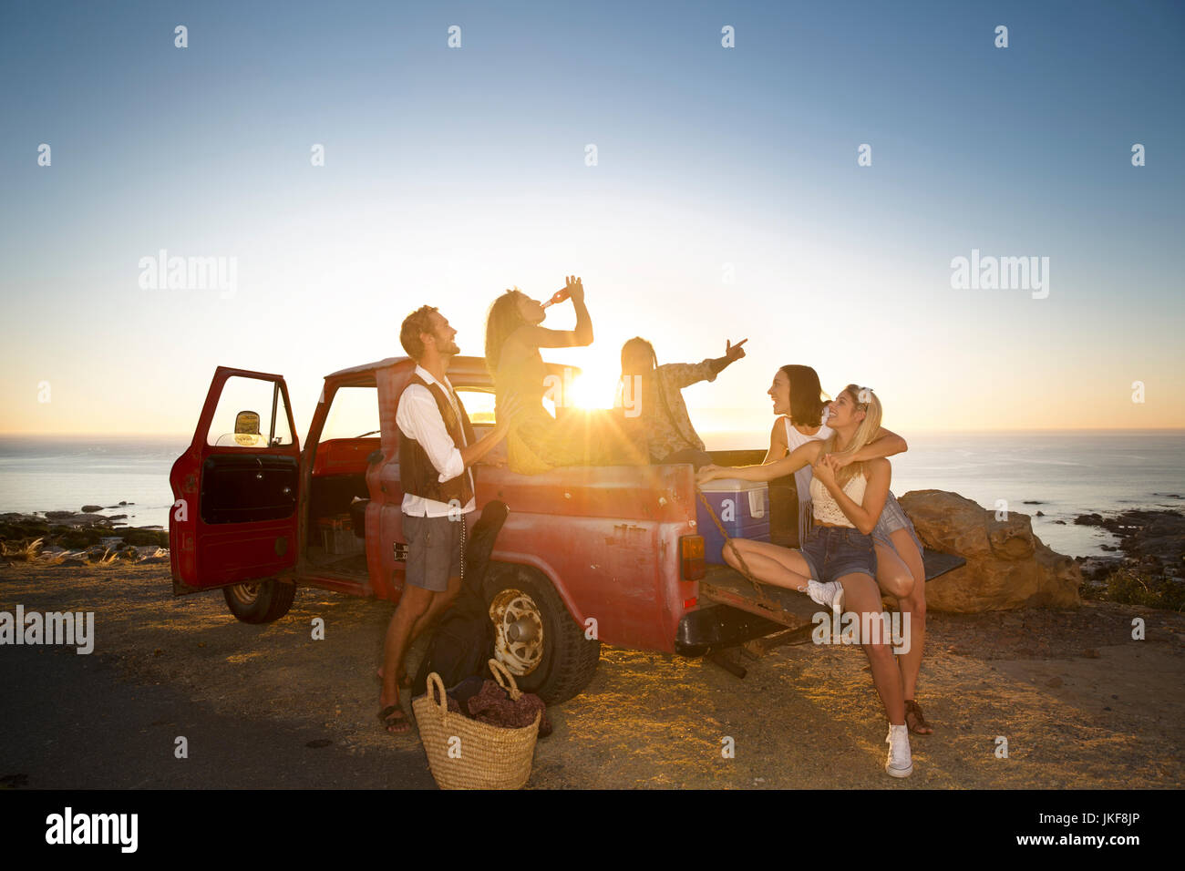 Happy young people outside pick up truck at the coast at sunset Stock ...