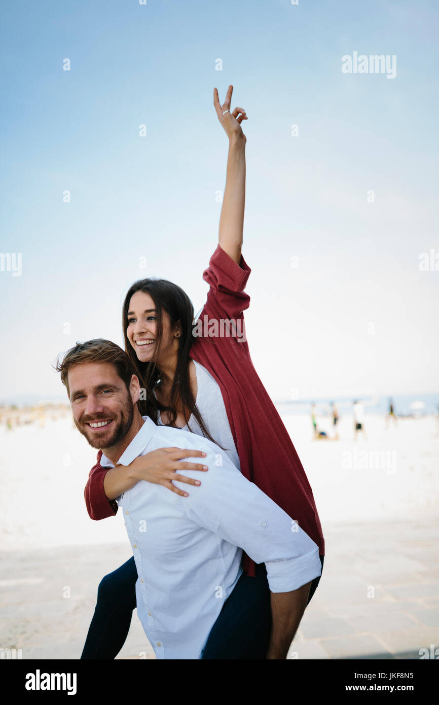 Man carrying girl friend piggy back Stock Photo - Alamy