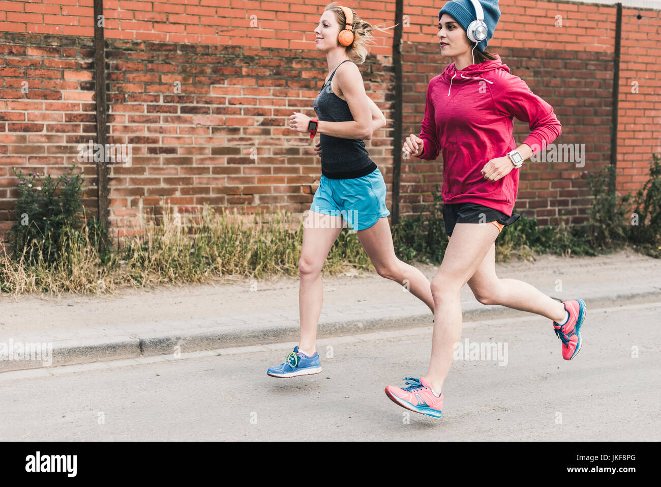 Two women running on the street Stock Photo - Alamy