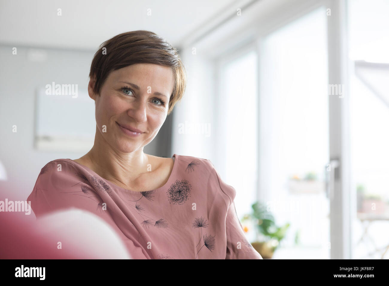 Portrait of smiling woman at home Stock Photo - Alamy