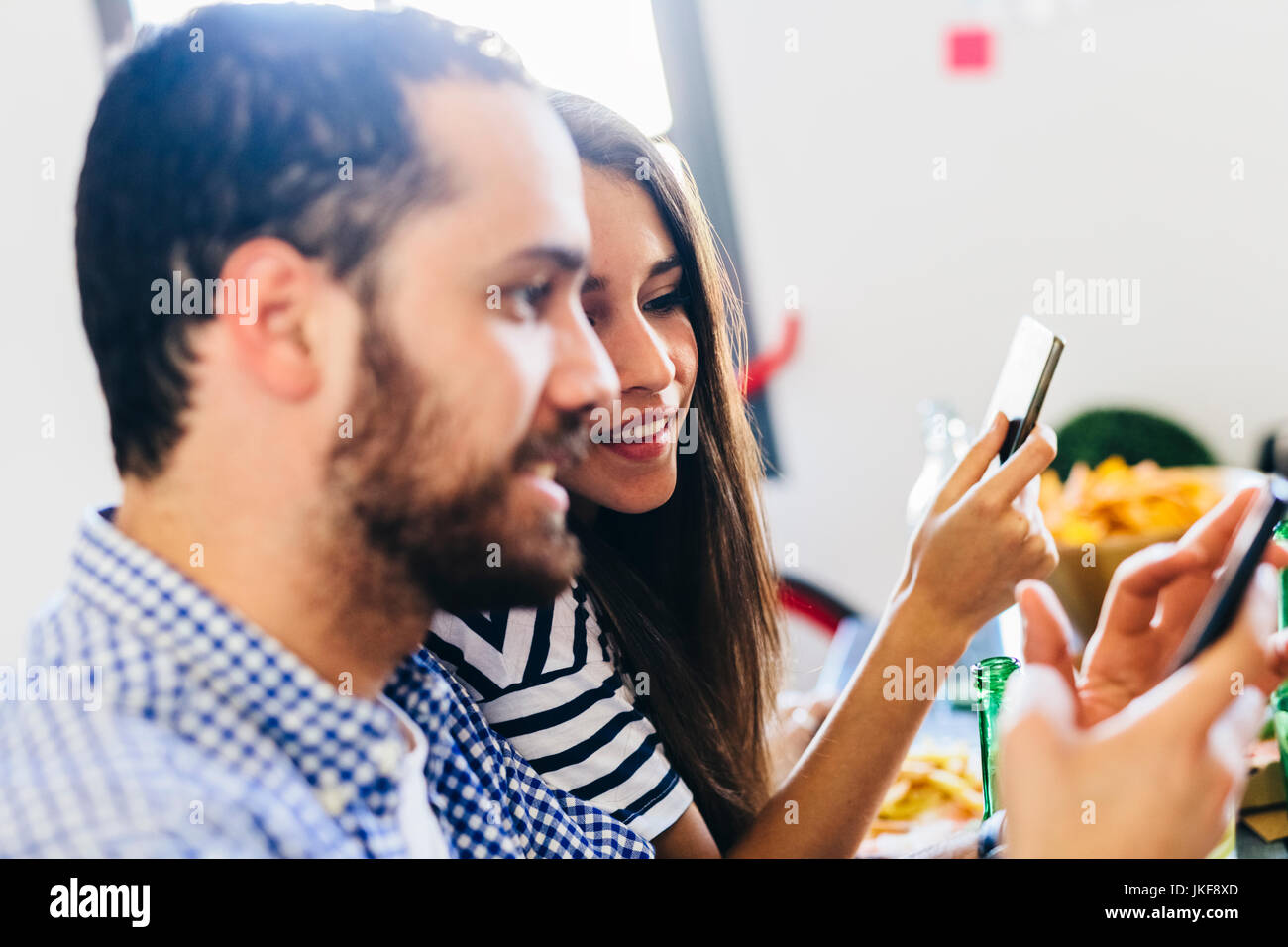 Couple looking at cell phone at dining table Stock Photo - Alamy