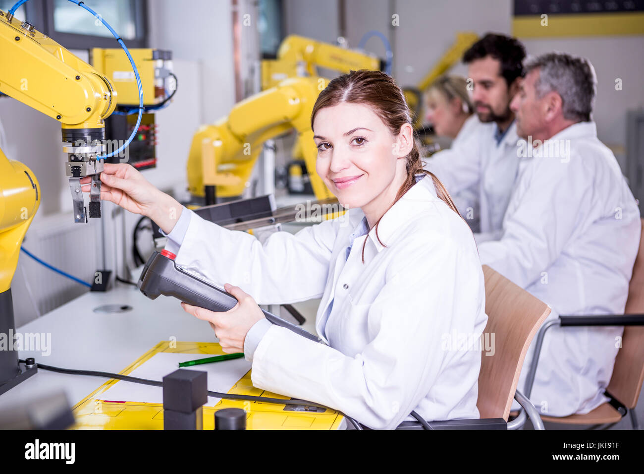 Portrait of smiling engineer examining industrial robot Stock Photo - Alamy