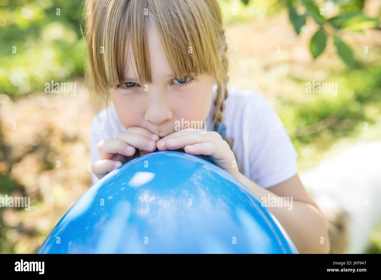 Girl inflating balloon outdoors Stock Photo - Alamy