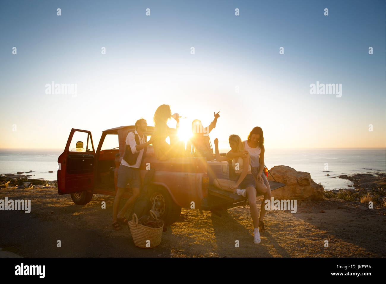 Happy young people outside pick up truck at the coast at sunset Stock ...