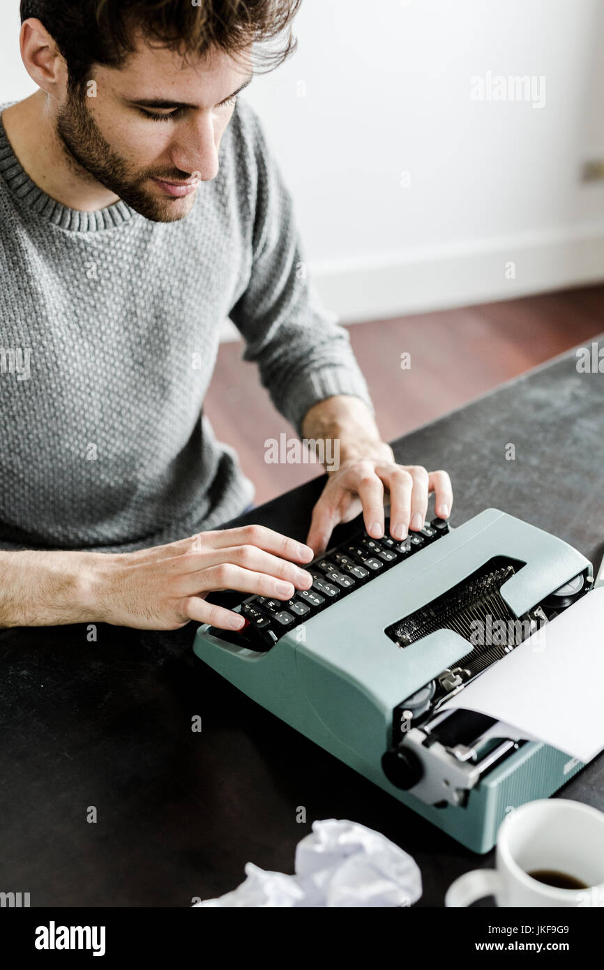 Young man at desk using typewriter Stock Photo - Alamy