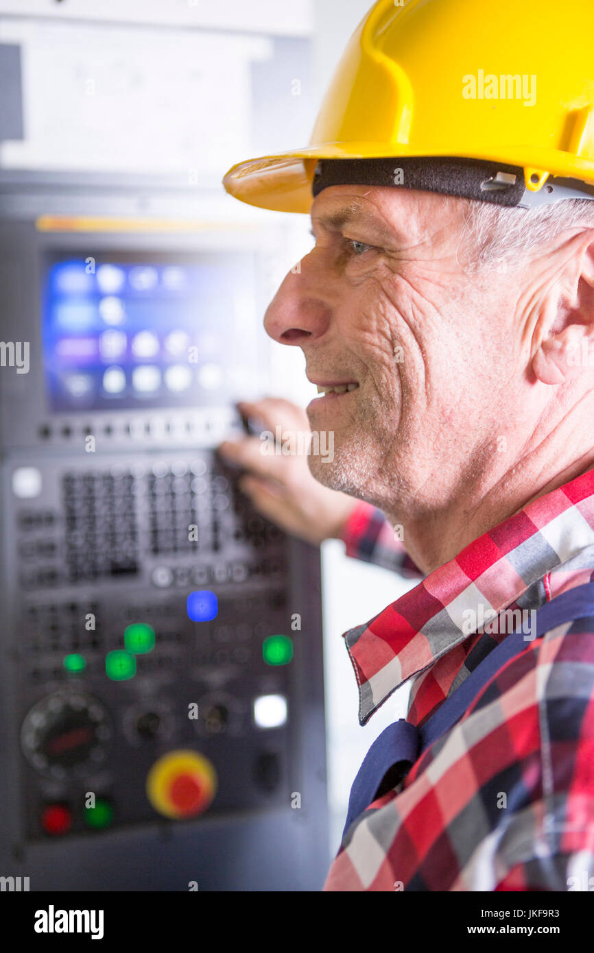 Worker operating high speed milling machine Stock Photo - Alamy