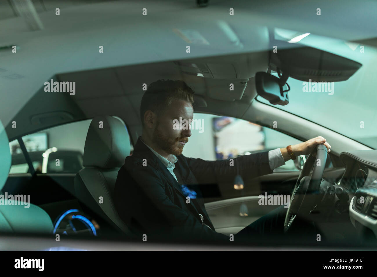 Businessman testing car in car dealership Stock Photo - Alamy