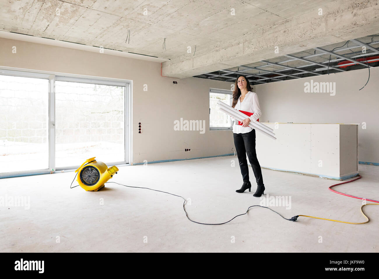 Woman in empty apartment looking around Stock Photo - Alamy