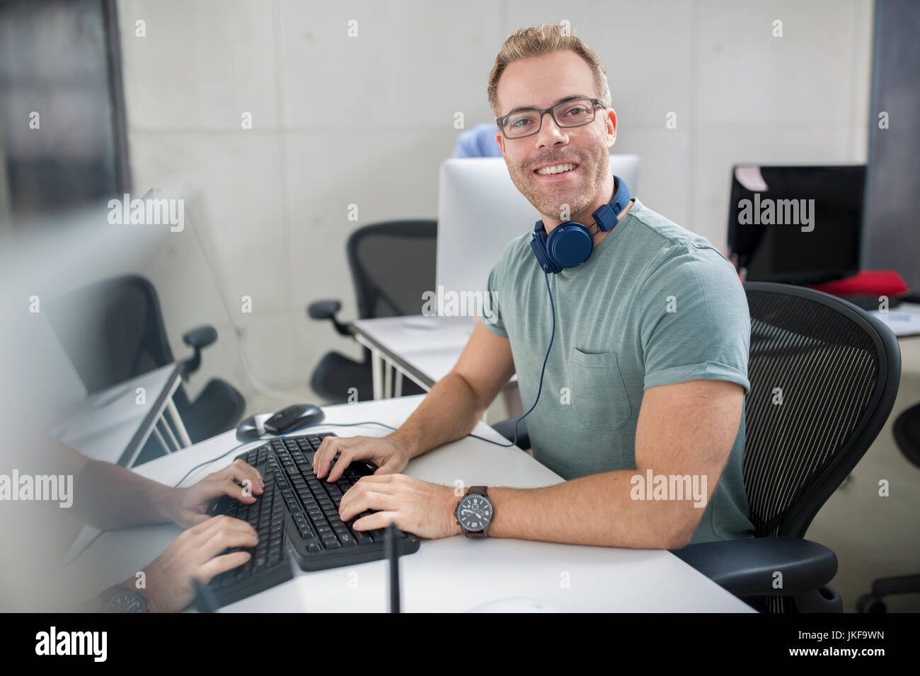 Employee at his desk smiling Stock Photo - Alamy