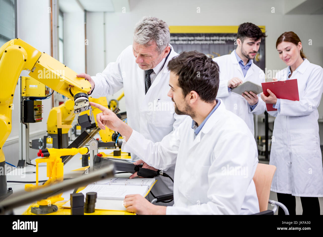 Engineers examining industrial robot Stock Photo - Alamy
