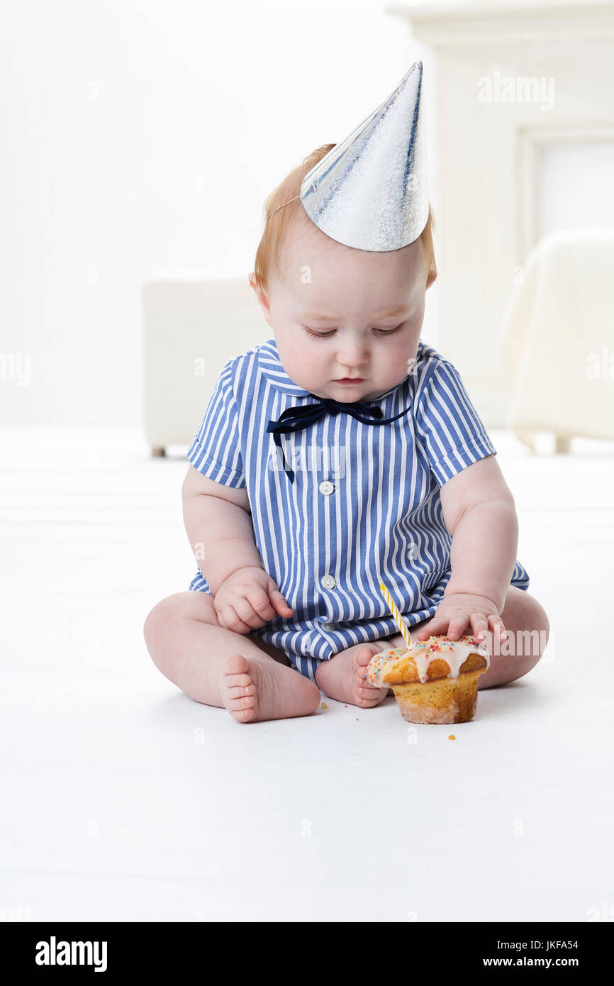 Baby boy testing birthday cake Stock Photo - Alamy