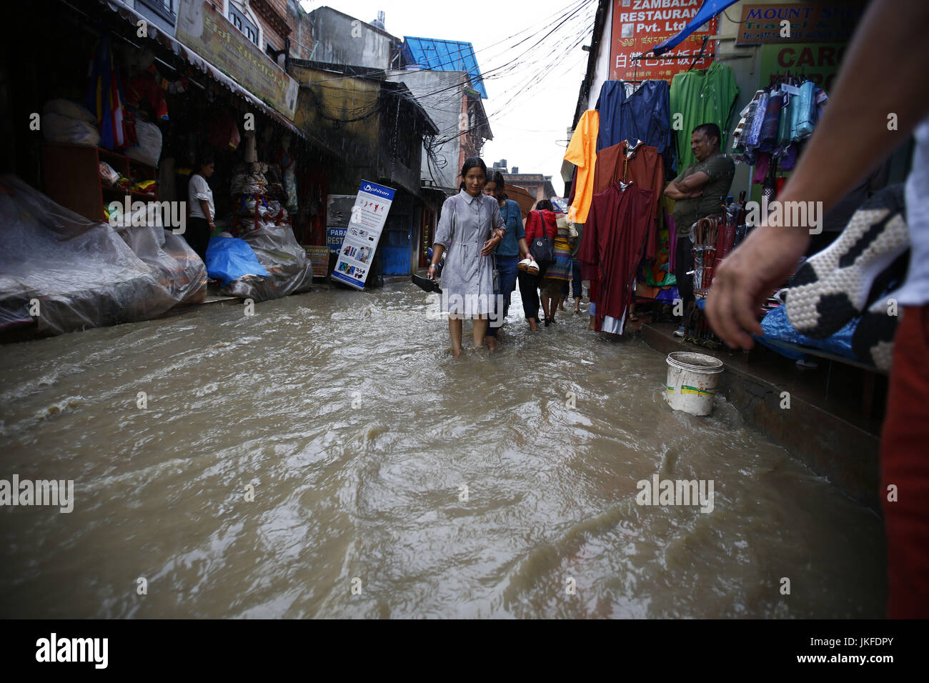 Kathmandu, Nepal. 23rd July, 2017. People walk along a flooded alley ...