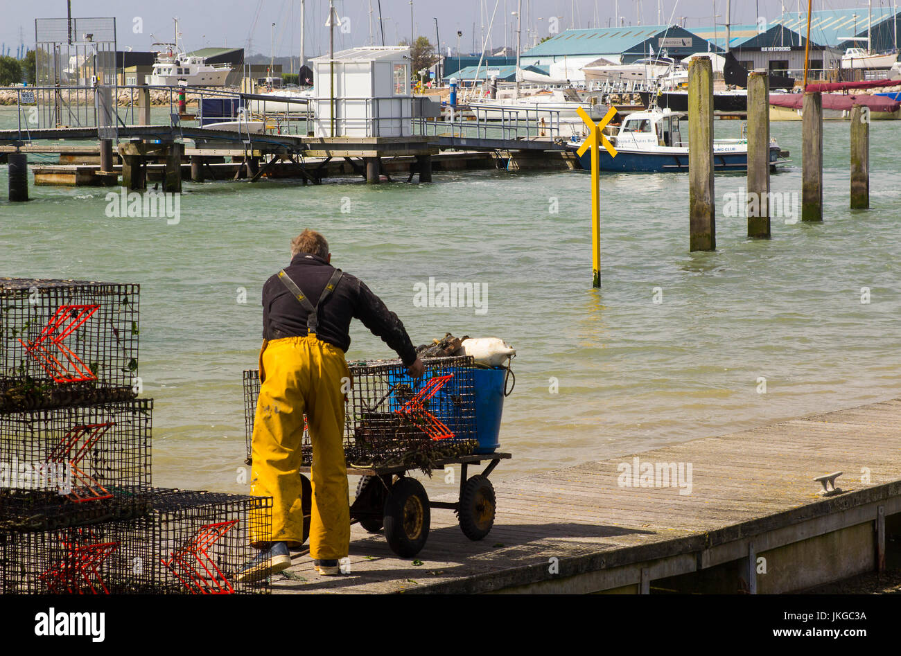 A crew member pushes a buggy along a floating pontoon at the harbour at ...