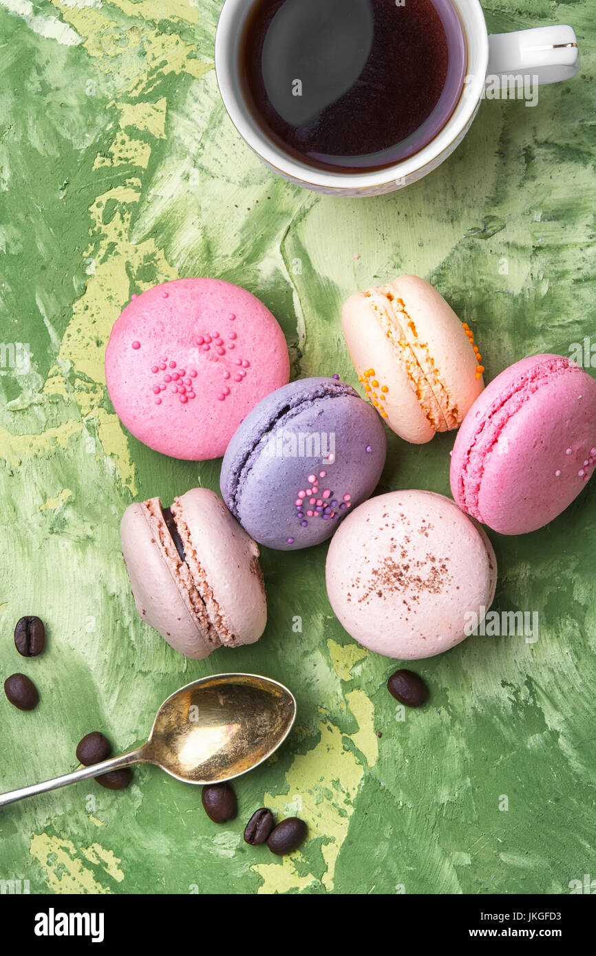 coffee and colorful French macaroons on green background Stock Photo ...