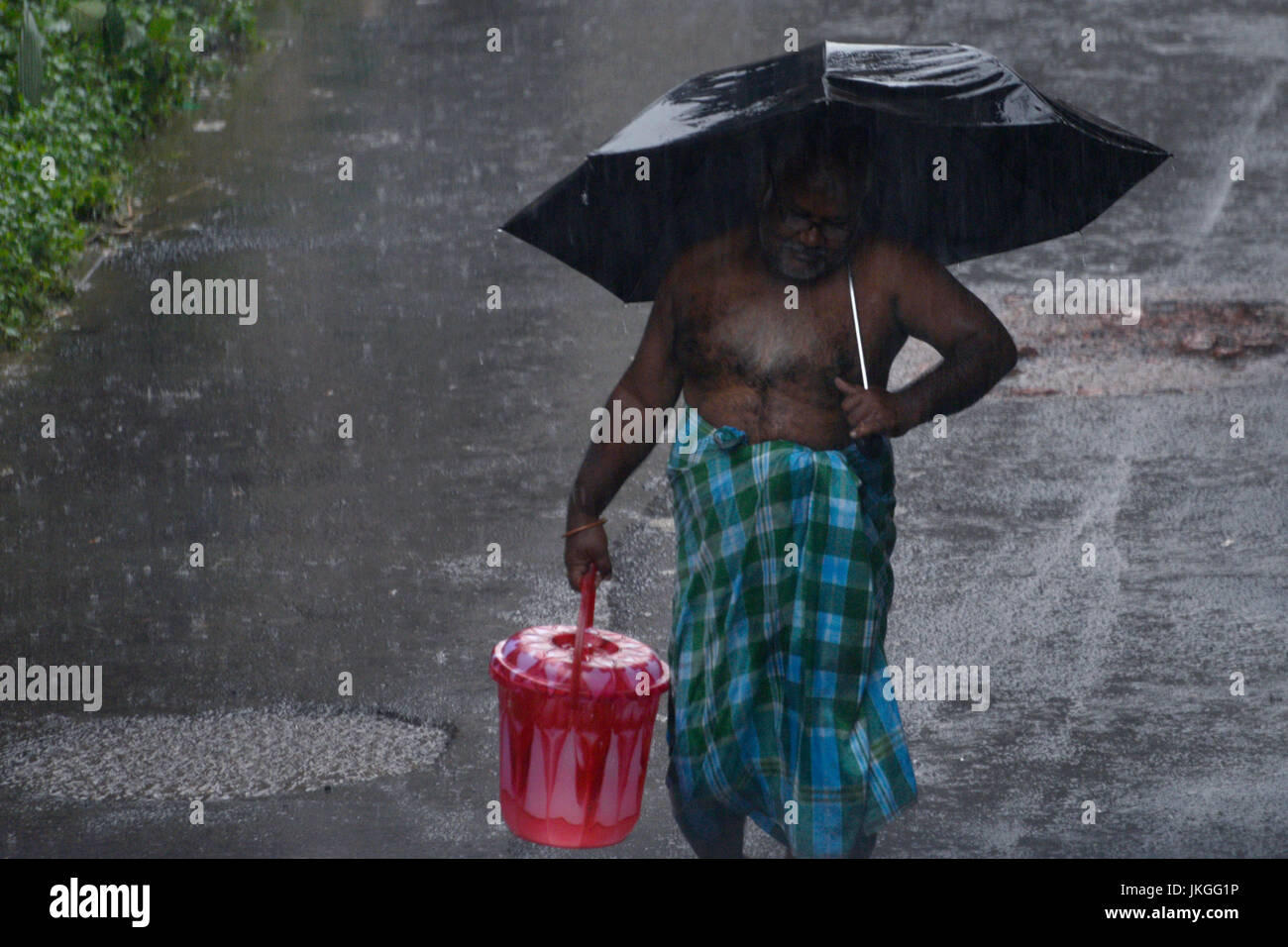 Indian man carries drink water in the rain in Kolkata. Overnight rain ...