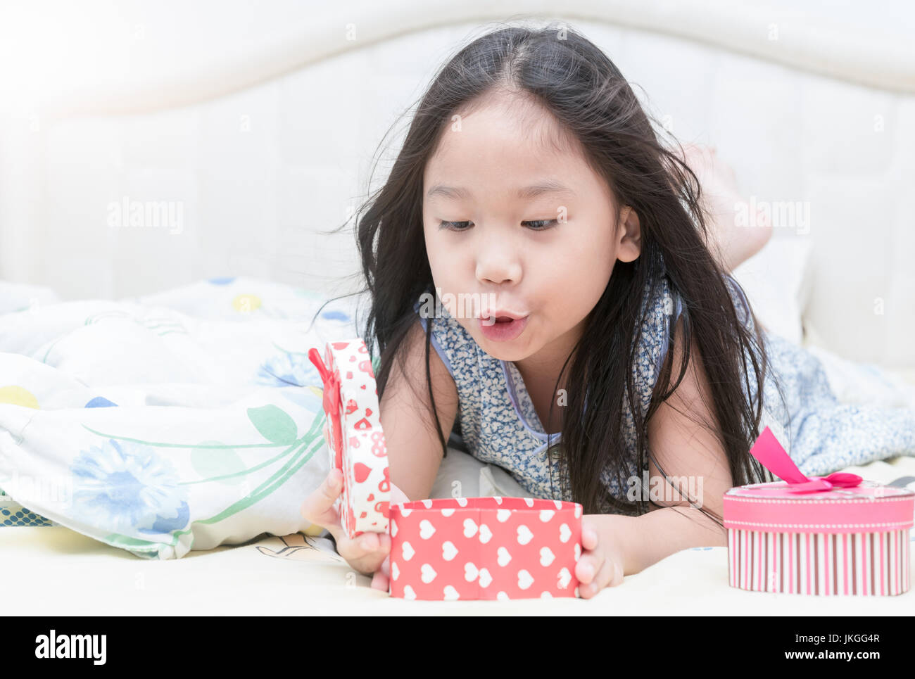 Happy little cute girl opening a Valentine's gift box Stock Photo - Alamy